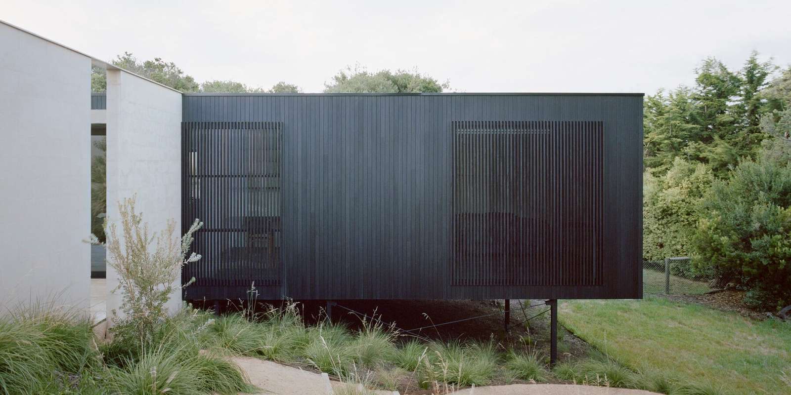 masonry blade walls & a floating timber volume compose ‘peninsula house ...